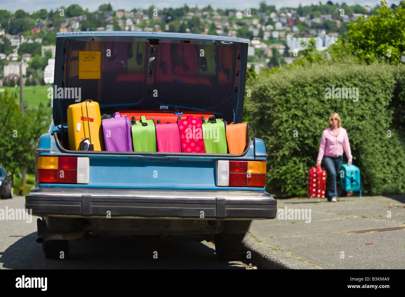 Car trunk loaded with colorful suitcases Stock Photo - Alamy