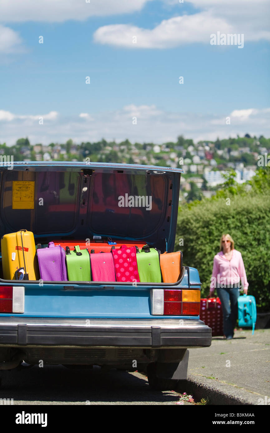 Car trunk loaded with colorful suitcases Stock Photo - Alamy