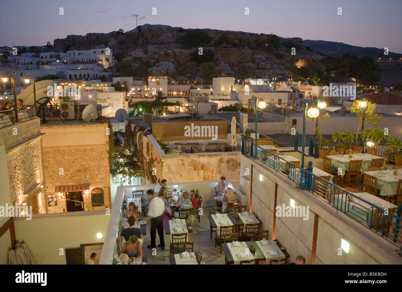 People in rooftop taverna at dusk, Lindos, Rhodes, Greece Stock Photo ...