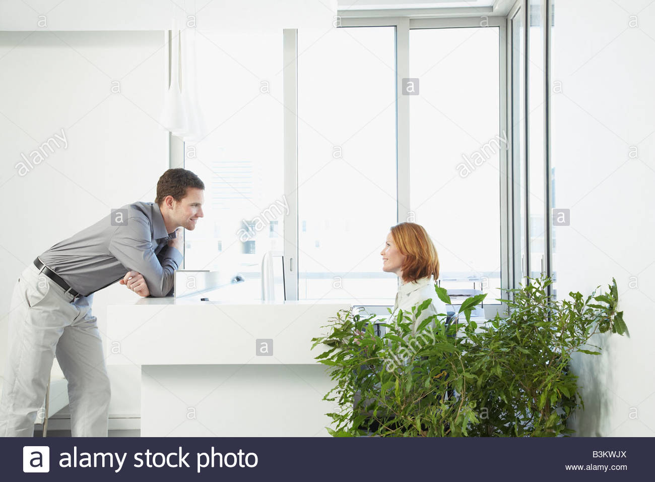 Man Standing Reception Desk Talking Stock Photos & Man Standing ...