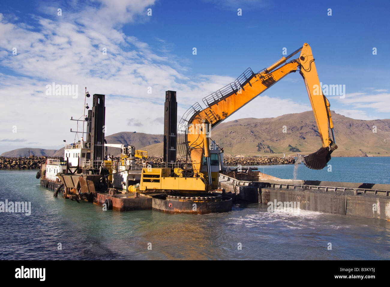 A front end digger on a spud barge and used for dredging operations ...