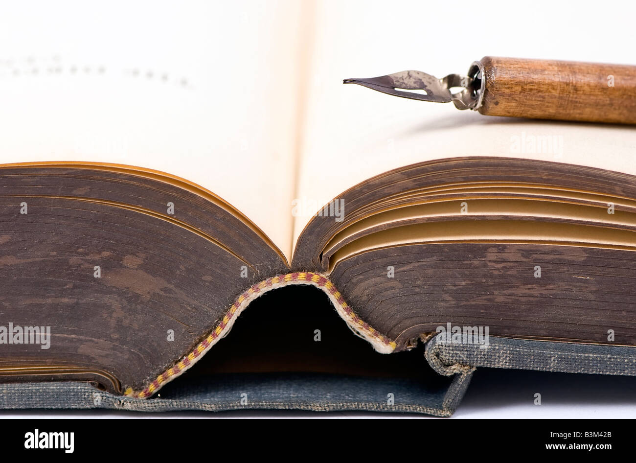 An old book that is open with a calligraphy pen on top Stock Photo - Alamy