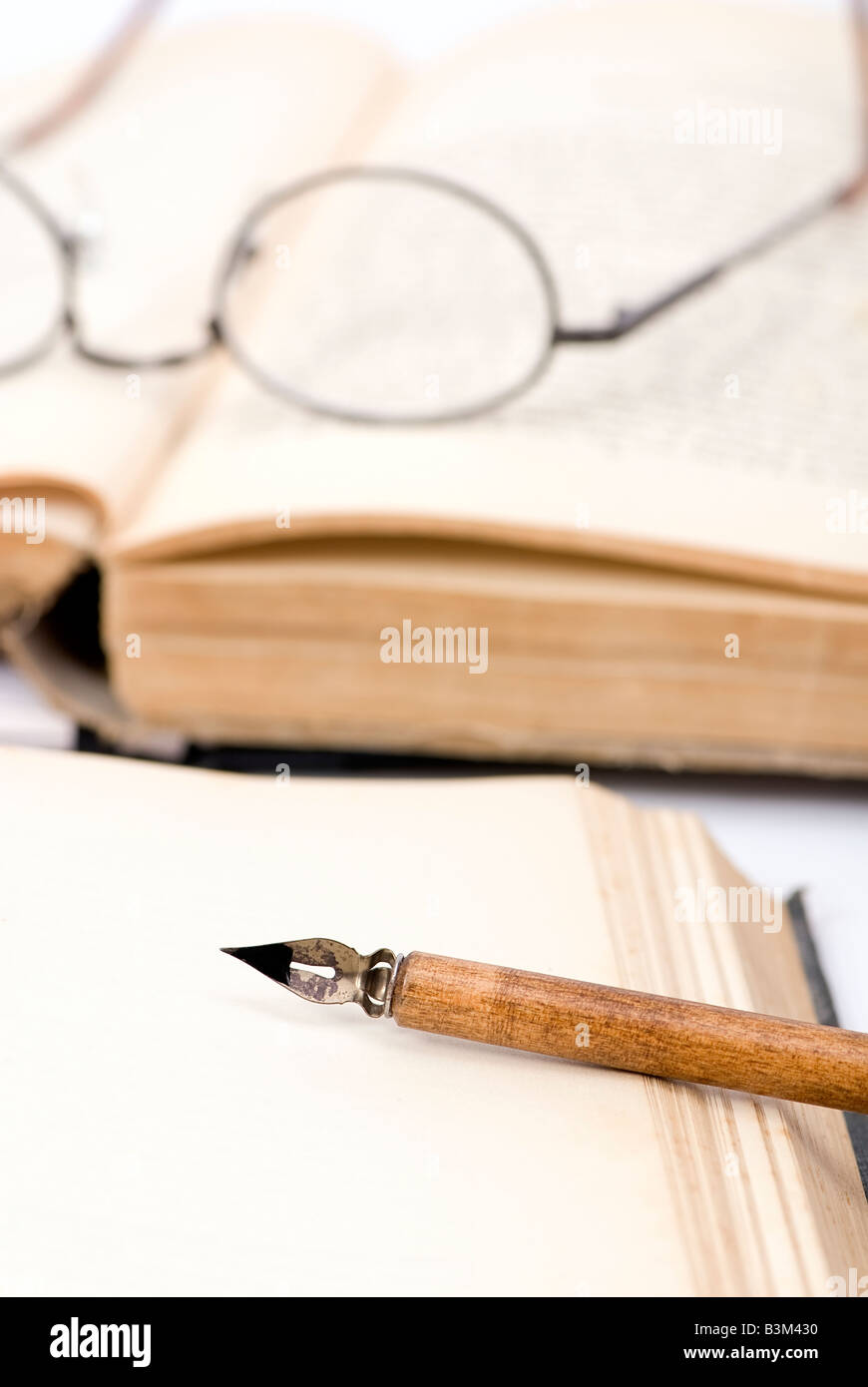 An old book that is open with a calligraphy pen on top Stock Photo - Alamy