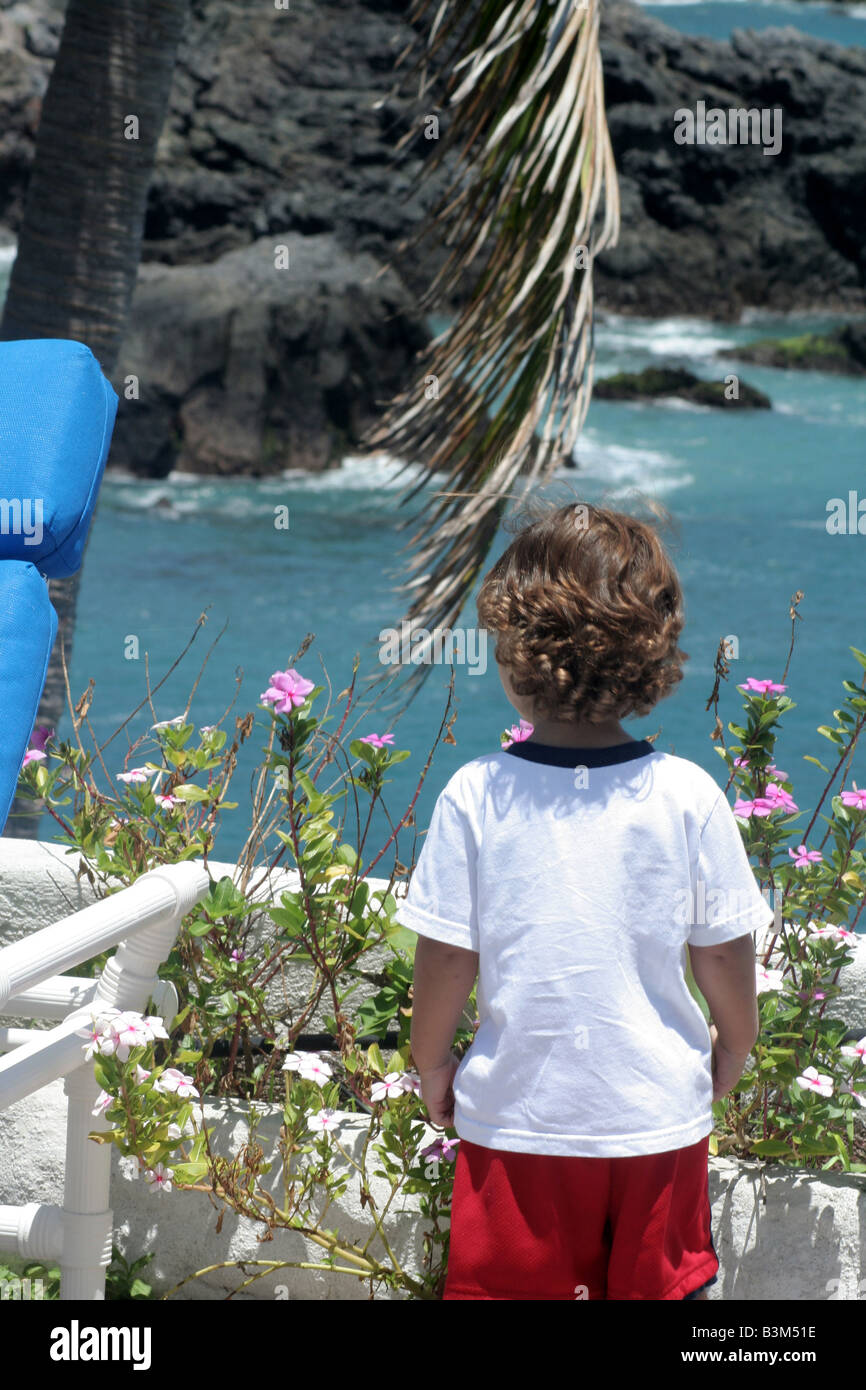 A young boy looking out over a rocky ocean coast Stock Photo - Alamy