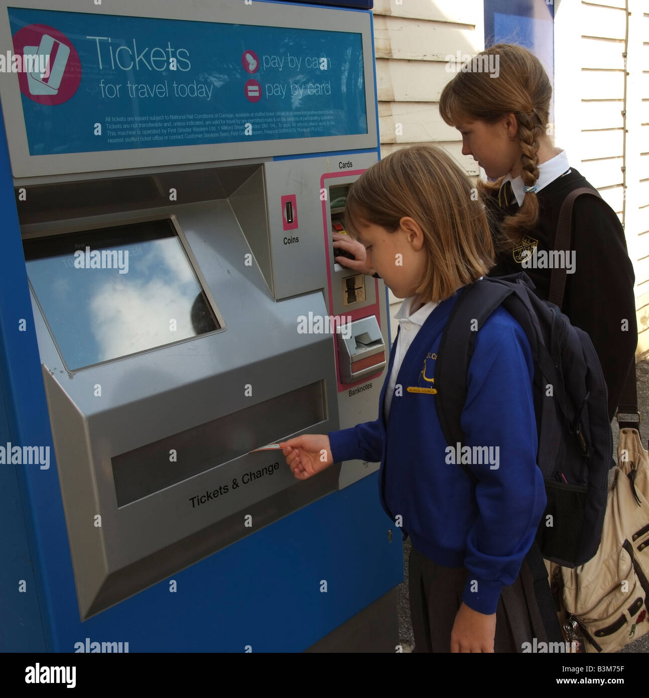 Young girls buying tickets for their railway journey on a station ...