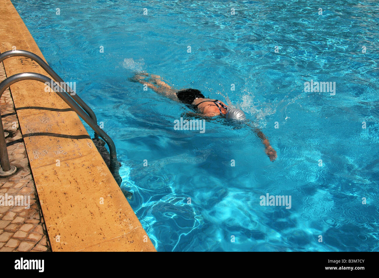 A woman swims in an outdoor swimming pool Stock Photo - Alamy