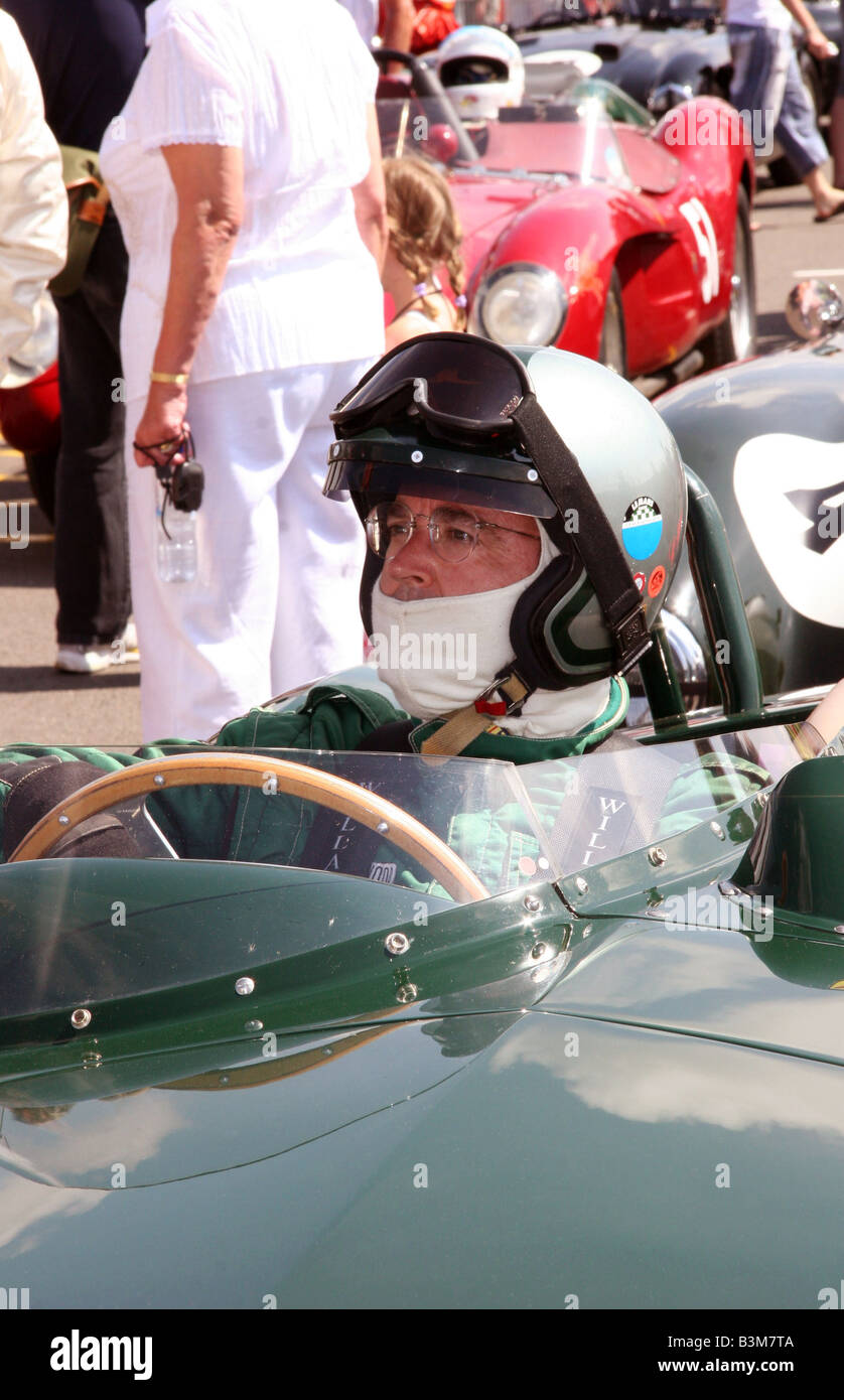 Racing driver in a classic racing car wearing a hemet on the start line ...