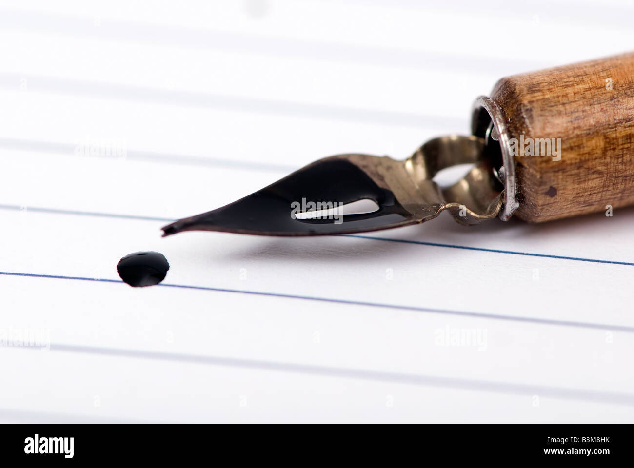 An old book that is open with a calligraphy pen on top Stock Photo - Alamy