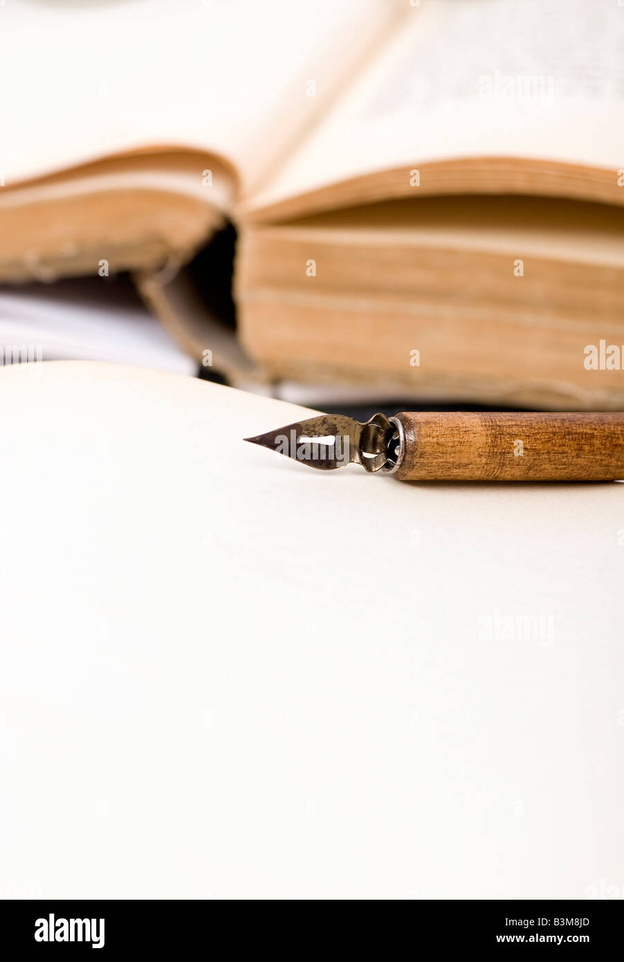 An old book that is open with a calligraphy pen on top Stock Photo - Alamy