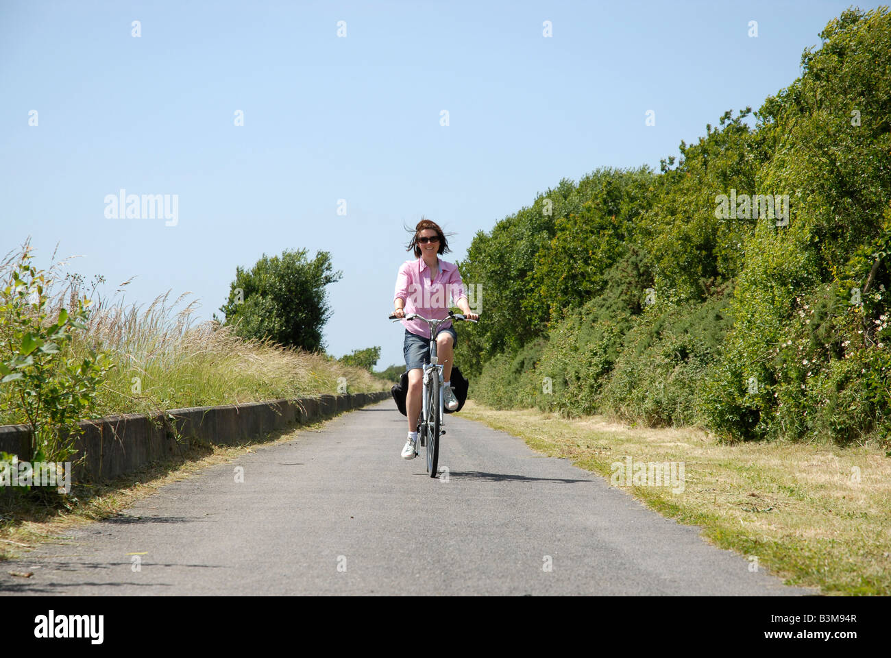 A cyclist riding along the Tarka Trail cycle path by the side of the ...