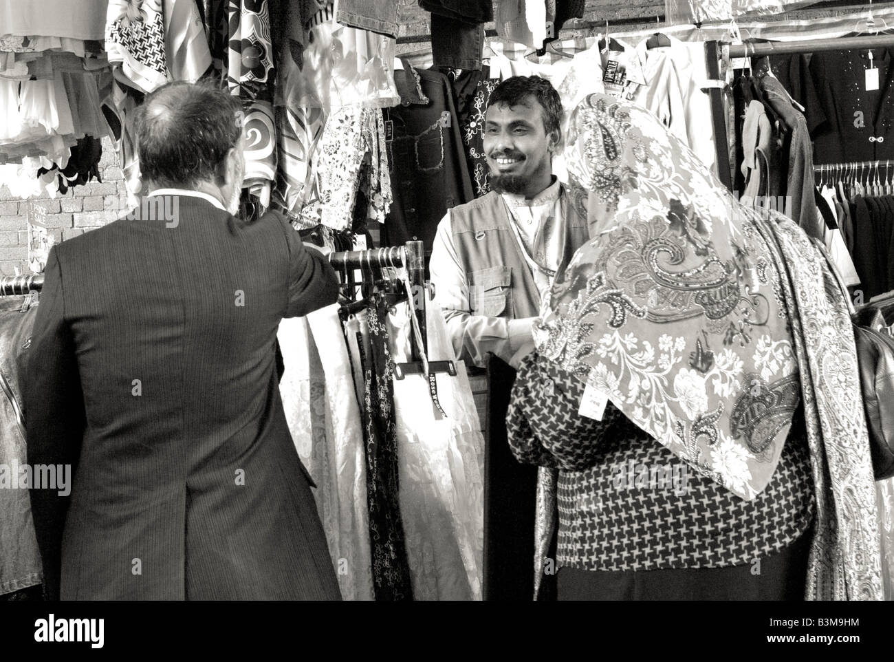 Man smiling selling clothes in this shop in Brixton street London 2008 ...