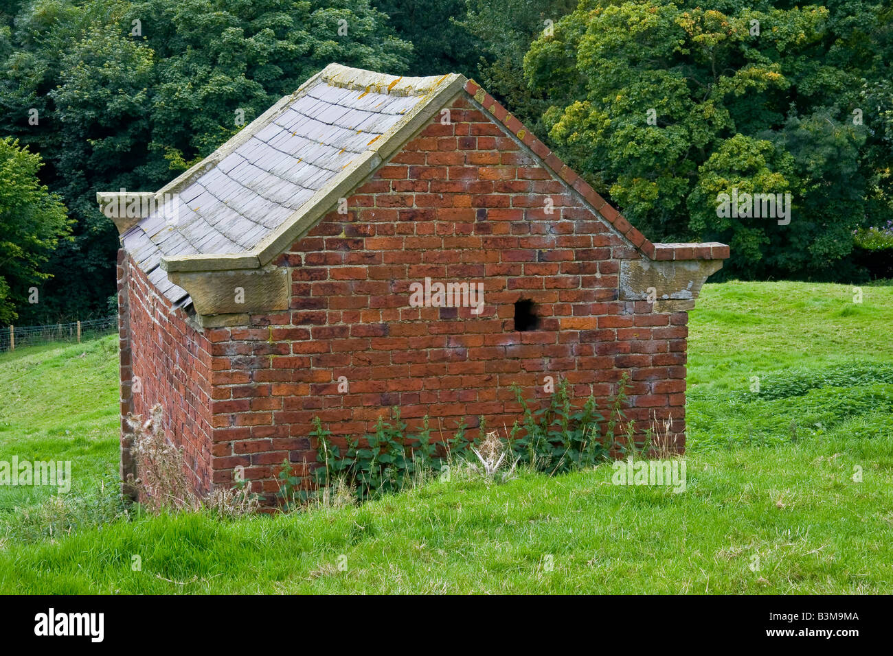 Quaint brick barn in green field Stock Photo - Alamy