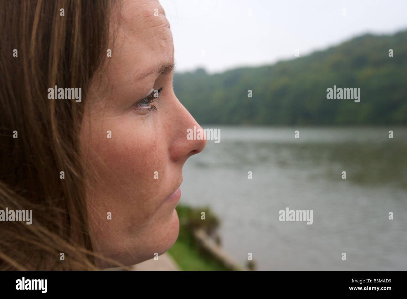Young lady looking thoughtfully out over a river Stock Photo - Alamy