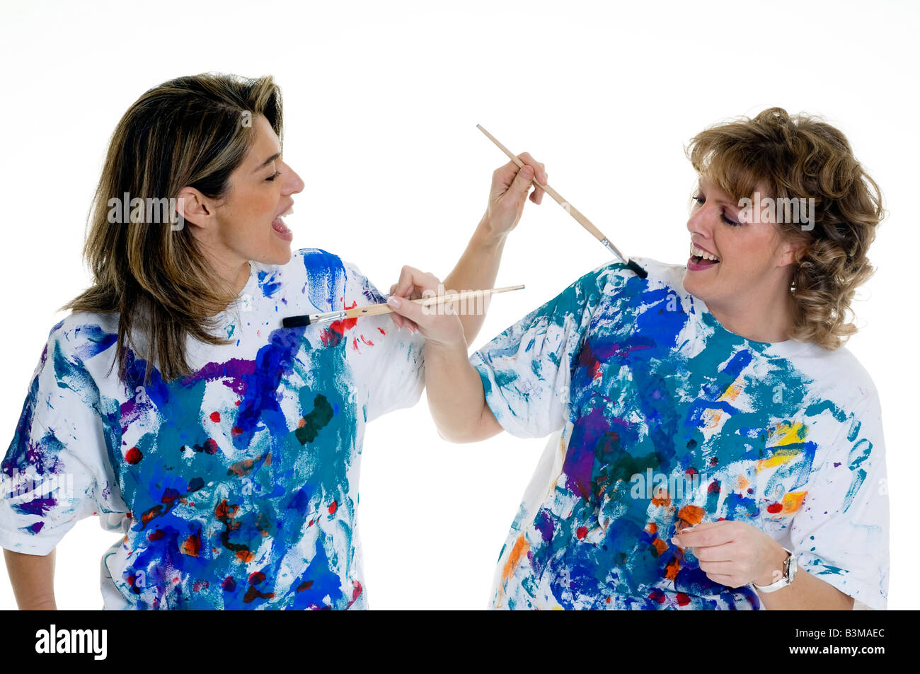 Two women having fun painting each other Stock Photo - Alamy