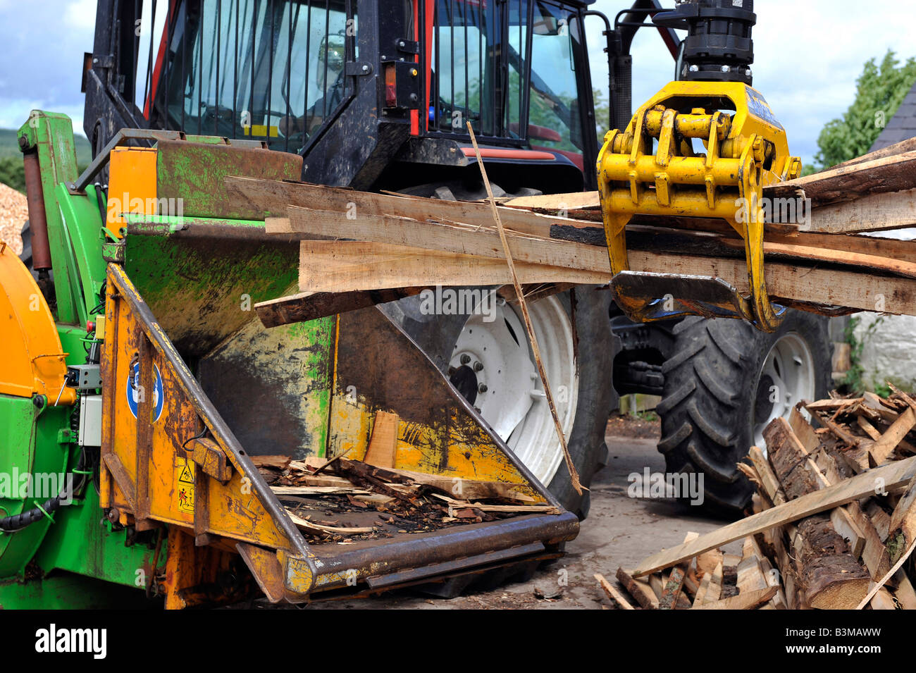 Tractor mounted chipper or shredder chips scrap wooden timber to be ...