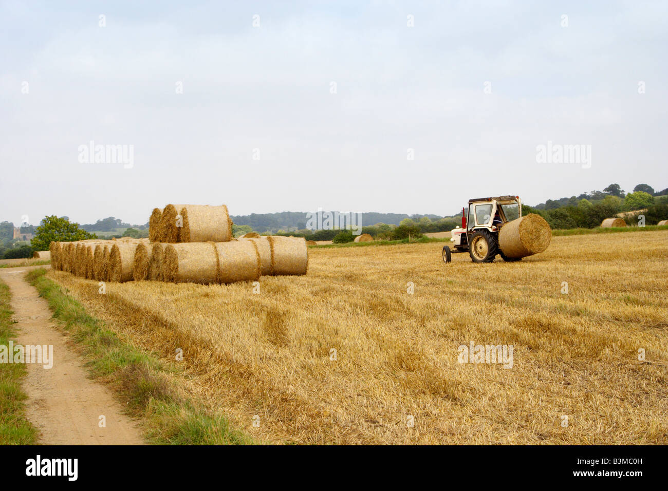 tractor gathering hay bales Stock Photo - Alamy