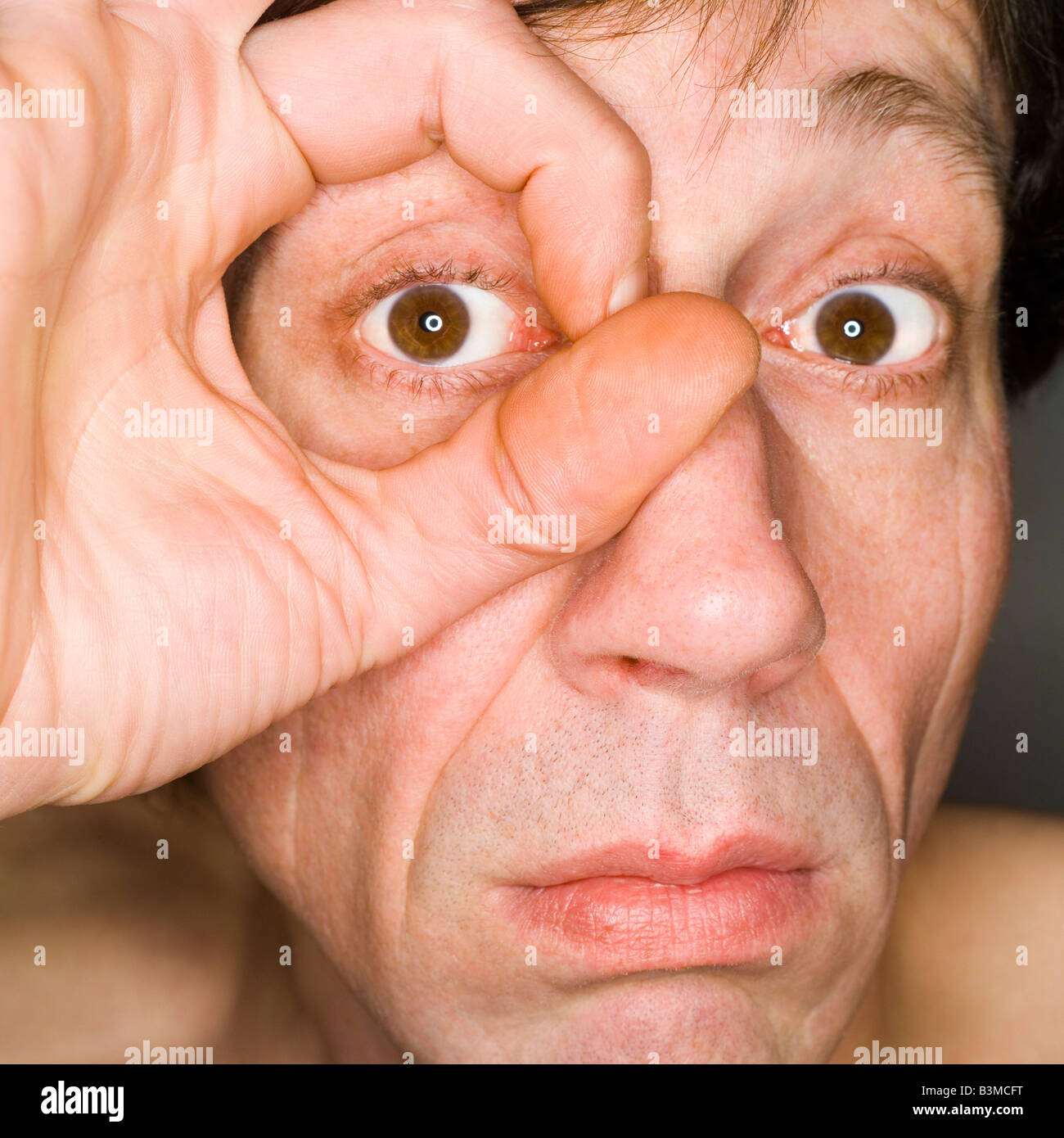 Man's face, fingers framing eye, close-up Stock Photo - Alamy