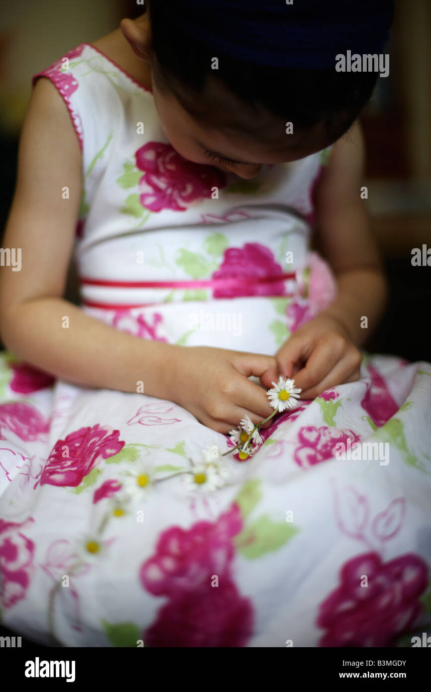 Five year old girl makes daisy chain Stock Photo - Alamy