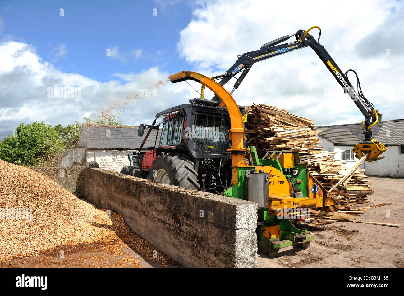 Tractor mounted chipper or shredder chips scrap wooden timber to be ...