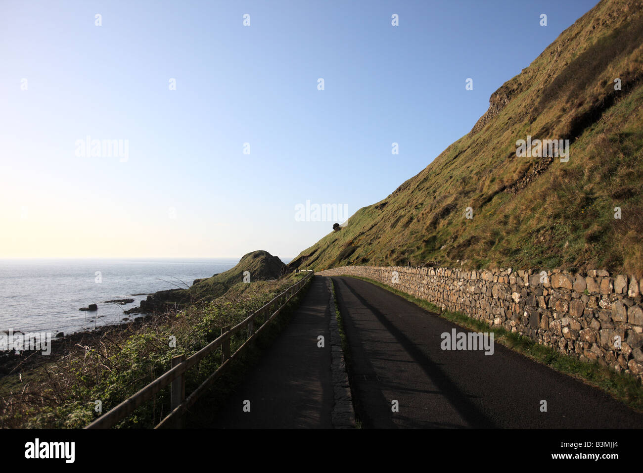 A nice triangulated picture where the sea, slope, sky, fence and road ...