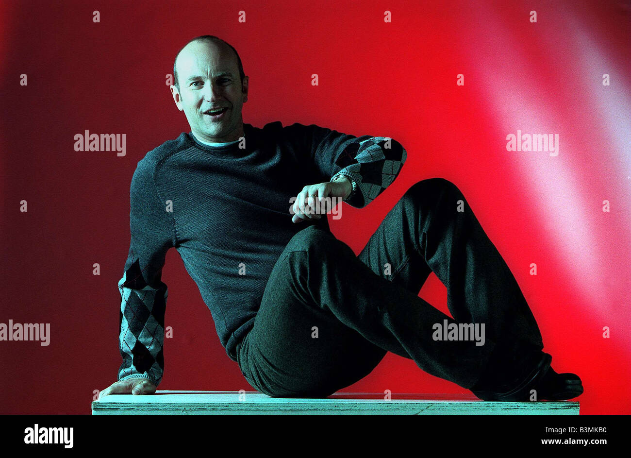 Fred MacAulay comedian November 2000 sitting on table wearing black ...