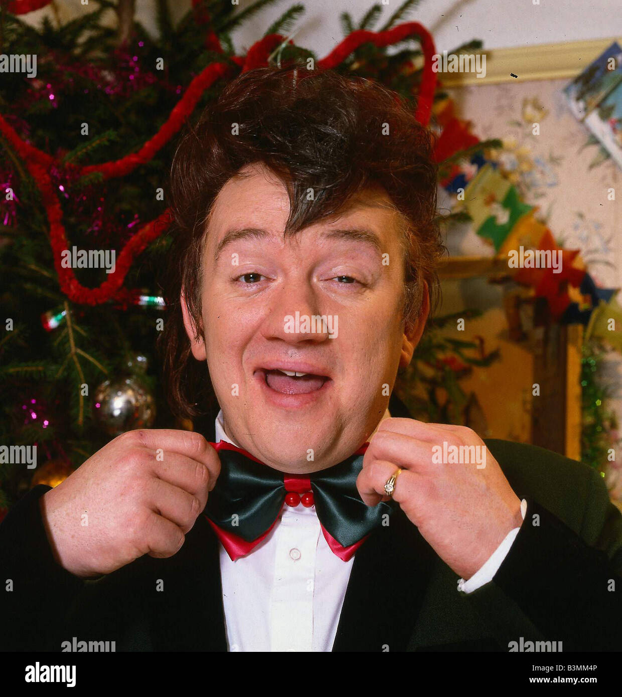Mel Smith actor comedian adjusting green red bow tie mirrorpix Stock ...