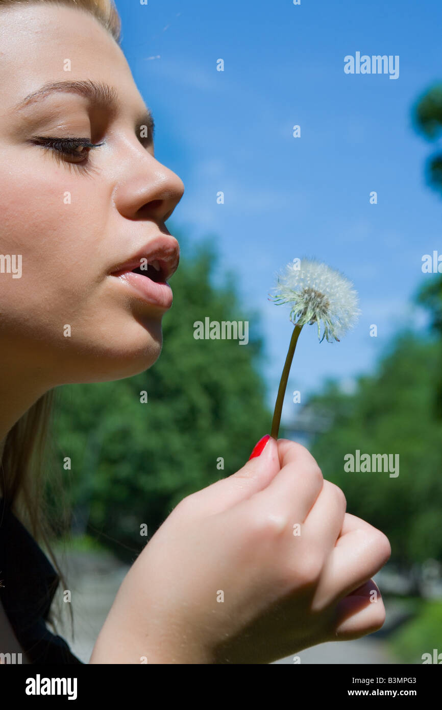 Girl blowing dandelion Stock Photo - Alamy