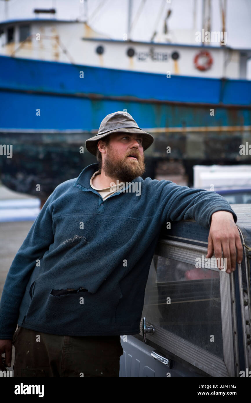A shipwright takes a moment to relax while working on the sailboat ...
