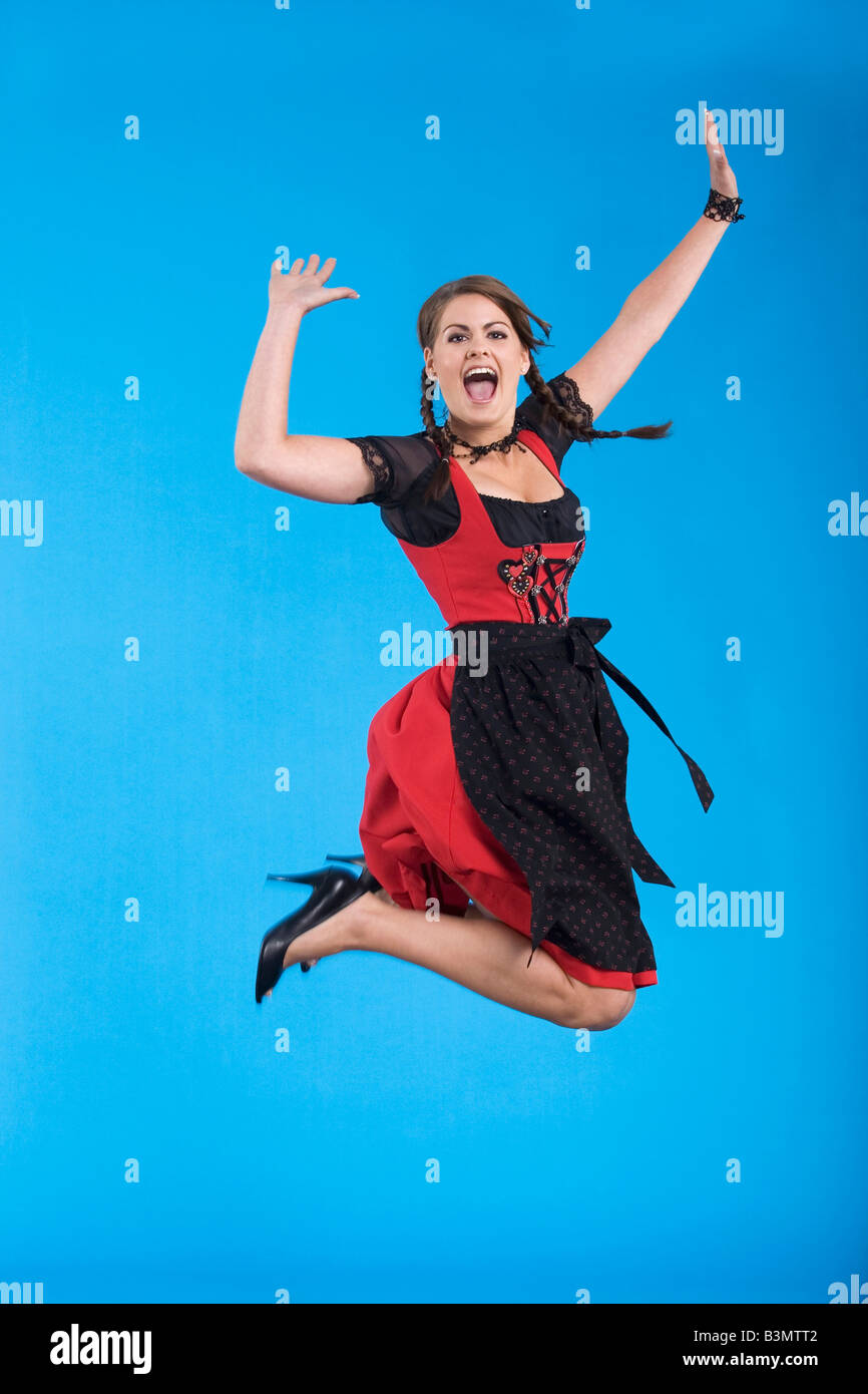 Young woman in traditional costume, jumping, portrait Stock Photo - Alamy