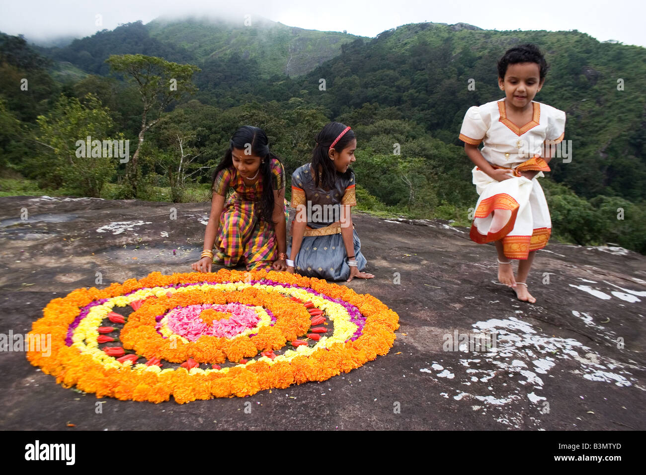 children arranging onam carpet Stock Photo - Alamy