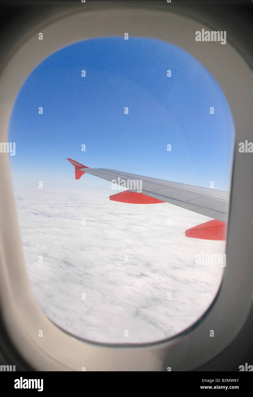 The wings of a passenger airliner and land and clouds as seen from the ...