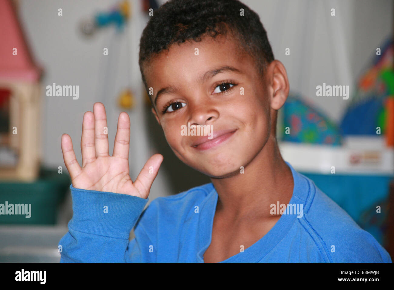 Happy Mixed race african american boy waving his hand Stock Photo - Alamy