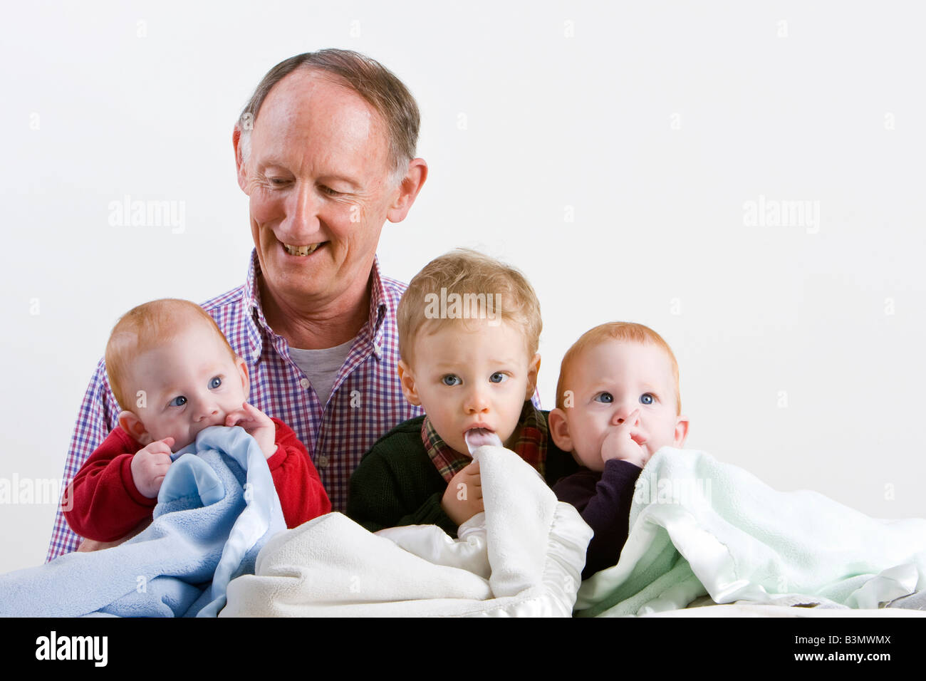 Proud grandfather with three grandsons including twins Stock Photo - Alamy