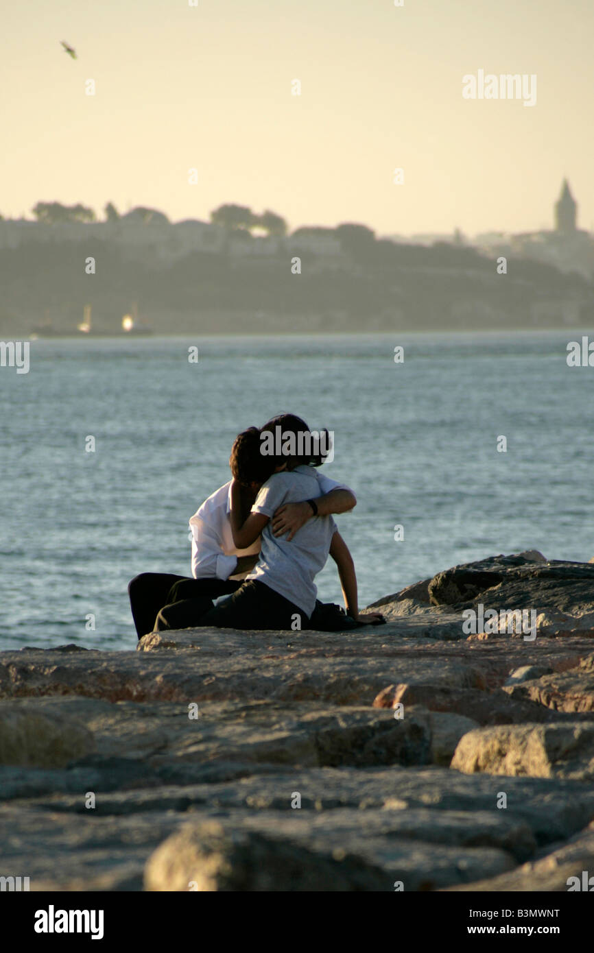 Young Turkish lovers in embrace on the waterfront by Kadikoy, Istanbul ...