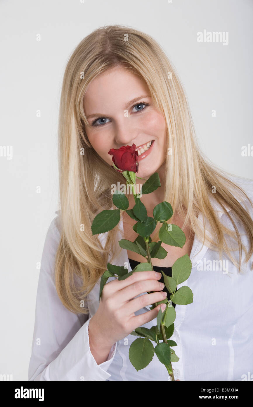Young woman holding a rose, smiling, portrait Stock Photo - Alamy