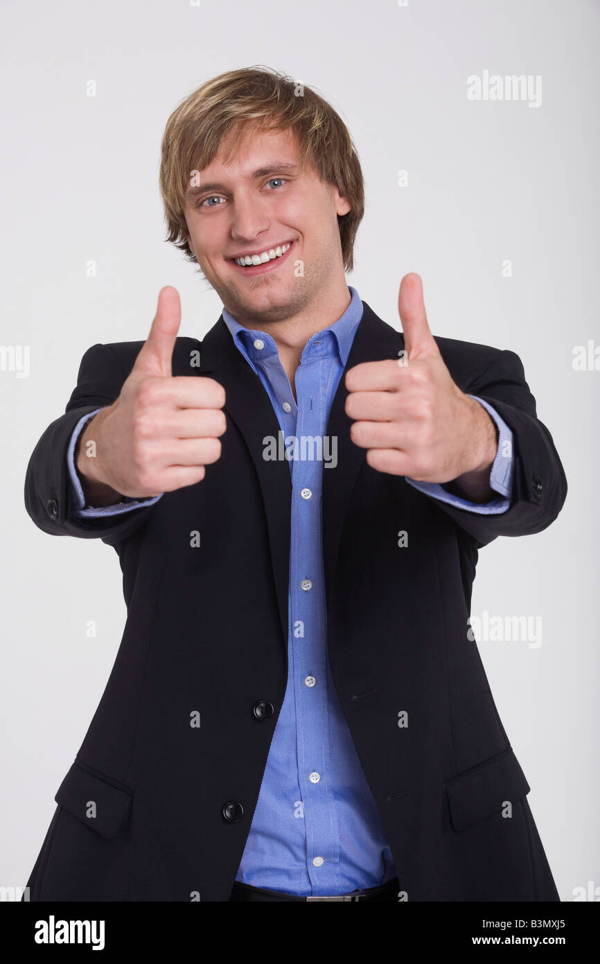 Young businessman, thumbs up, portrait Stock Photo - Alamy