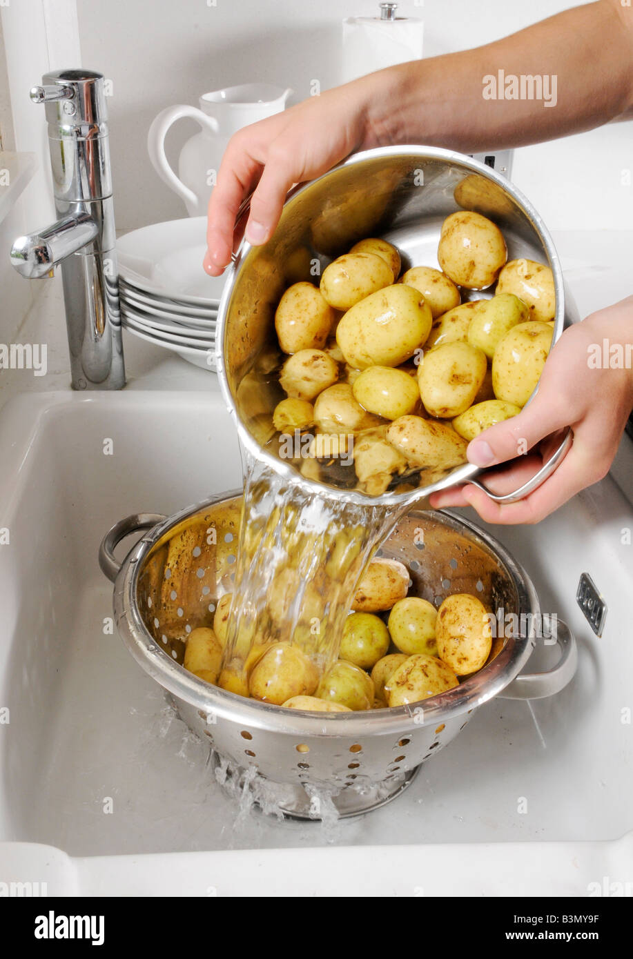 MAN DRAINING NEW POTATOES INTO COLLANDER Stock Photo - Alamy
