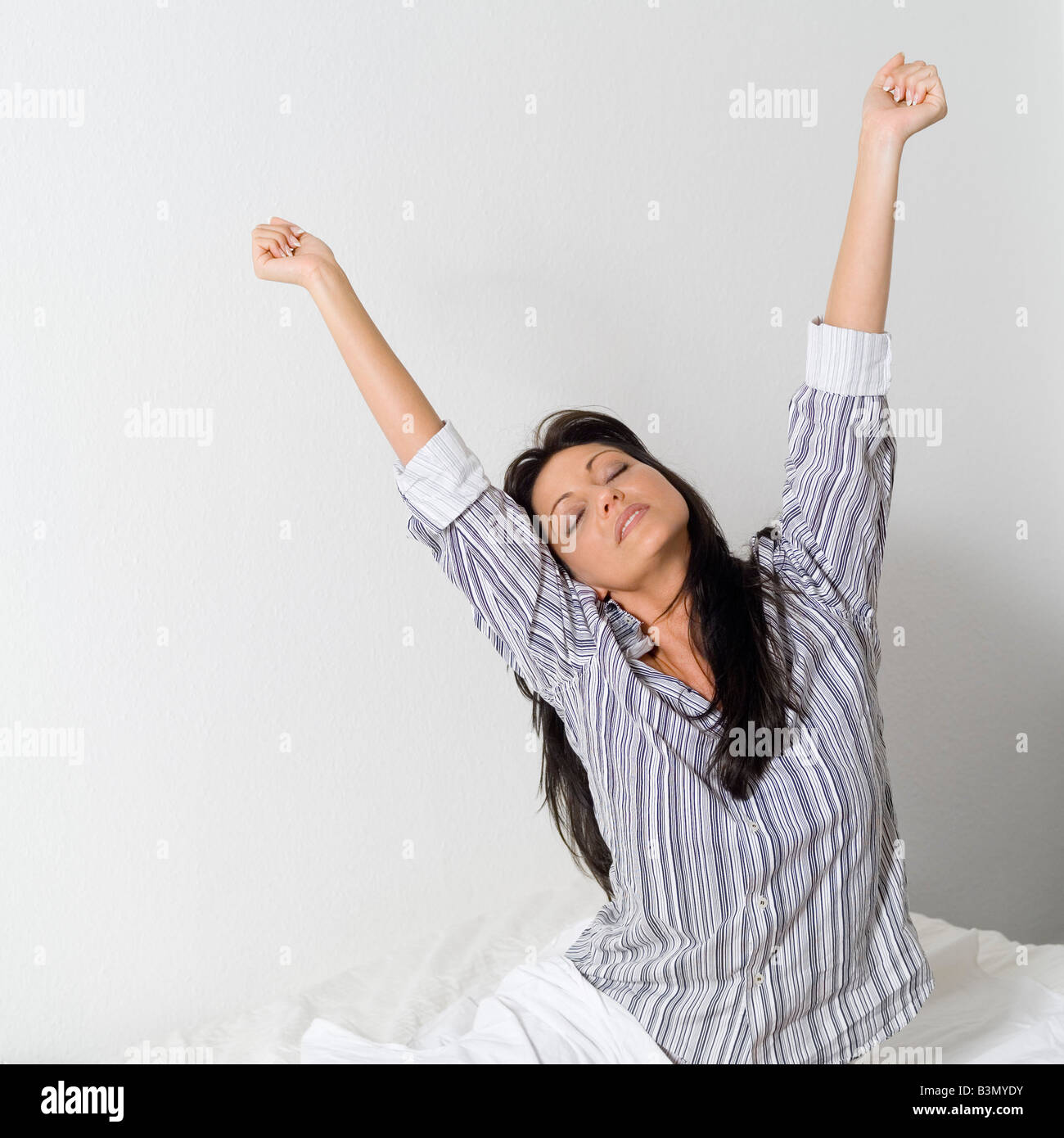Young woman stretching in bed, portrait Stock Photo - Alamy