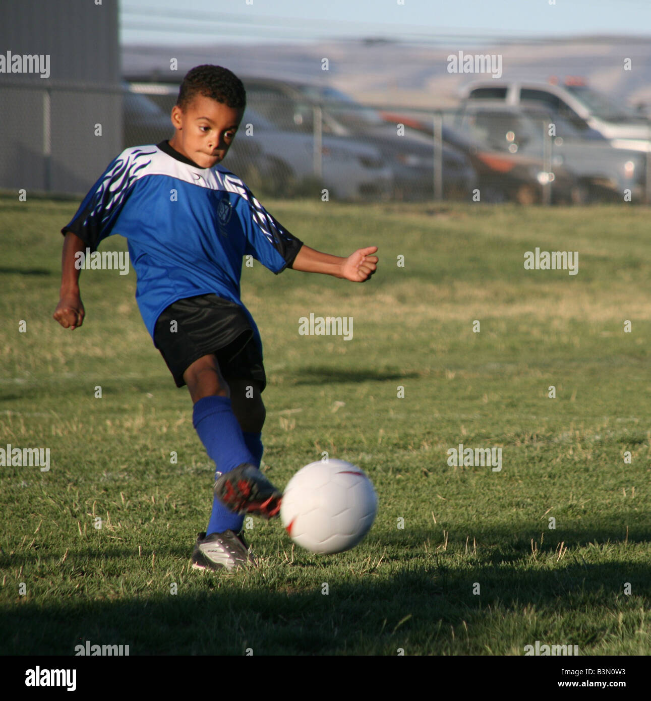 boy soccer player kicks ball Stock Photo - Alamy