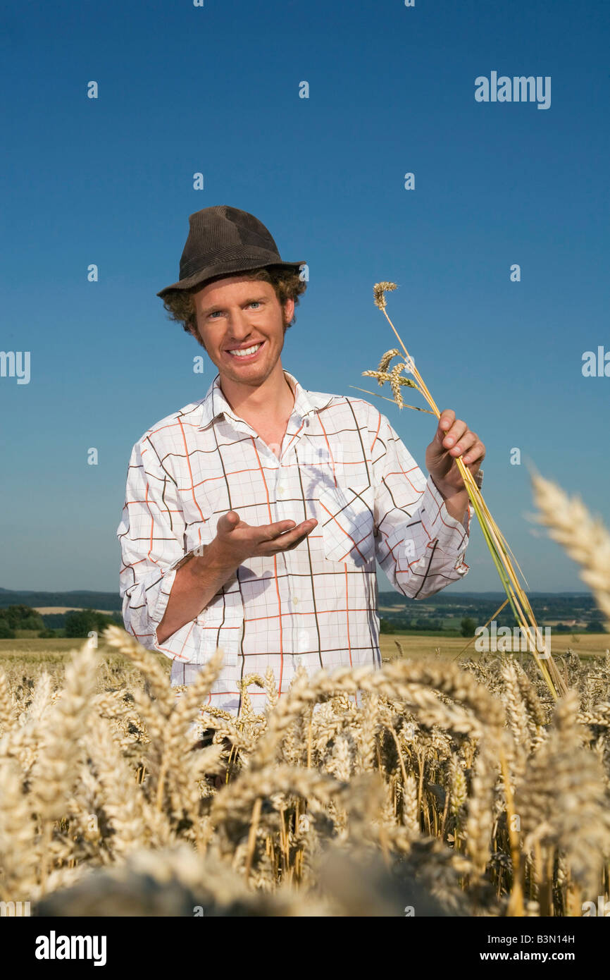 Germany, Bavaria, Farmer examining wheat growing in field Stock Photo ...