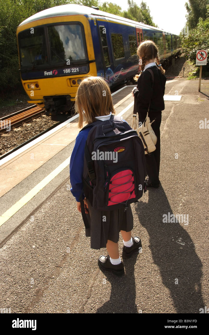 Young girls waiting for their train on a railway station platform ...