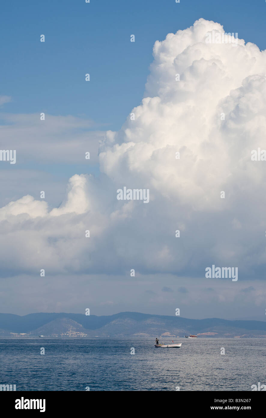 Fishing under a Cloud. A large cumulus cloud forms a backdrop for a ...