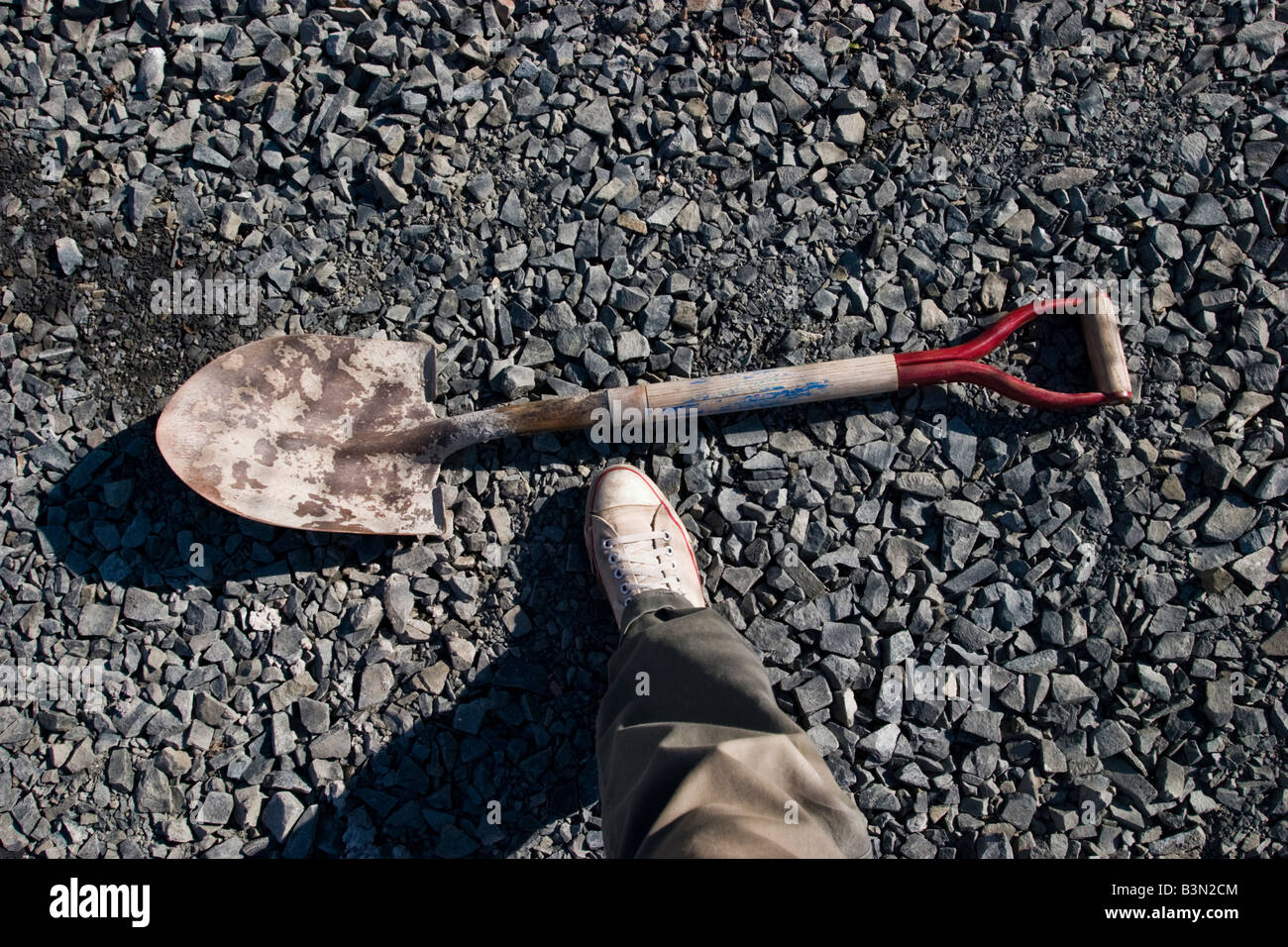 Shovel next to a foot laying on the ground in a construction area in ...