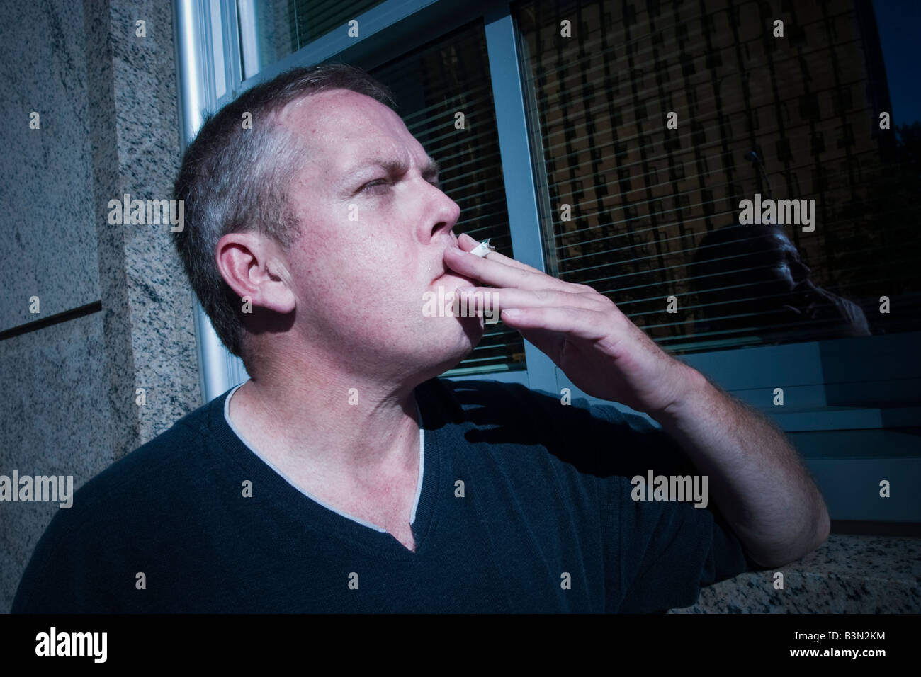 Middle age man smoking a cigarette posed in front of a building Model ...