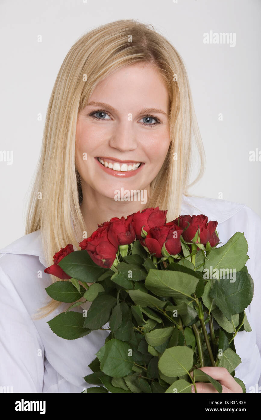 Young woman holding a bunch of roses, smiling, portrait Stock Photo - Alamy