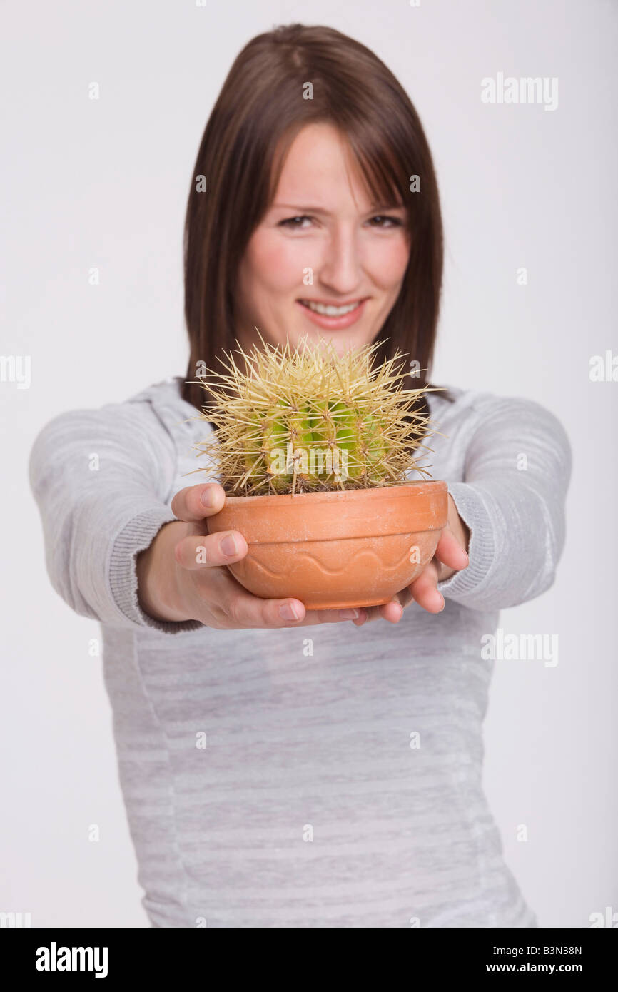 Young girl holding a flowerpot with cactus Stock Photo - Alamy