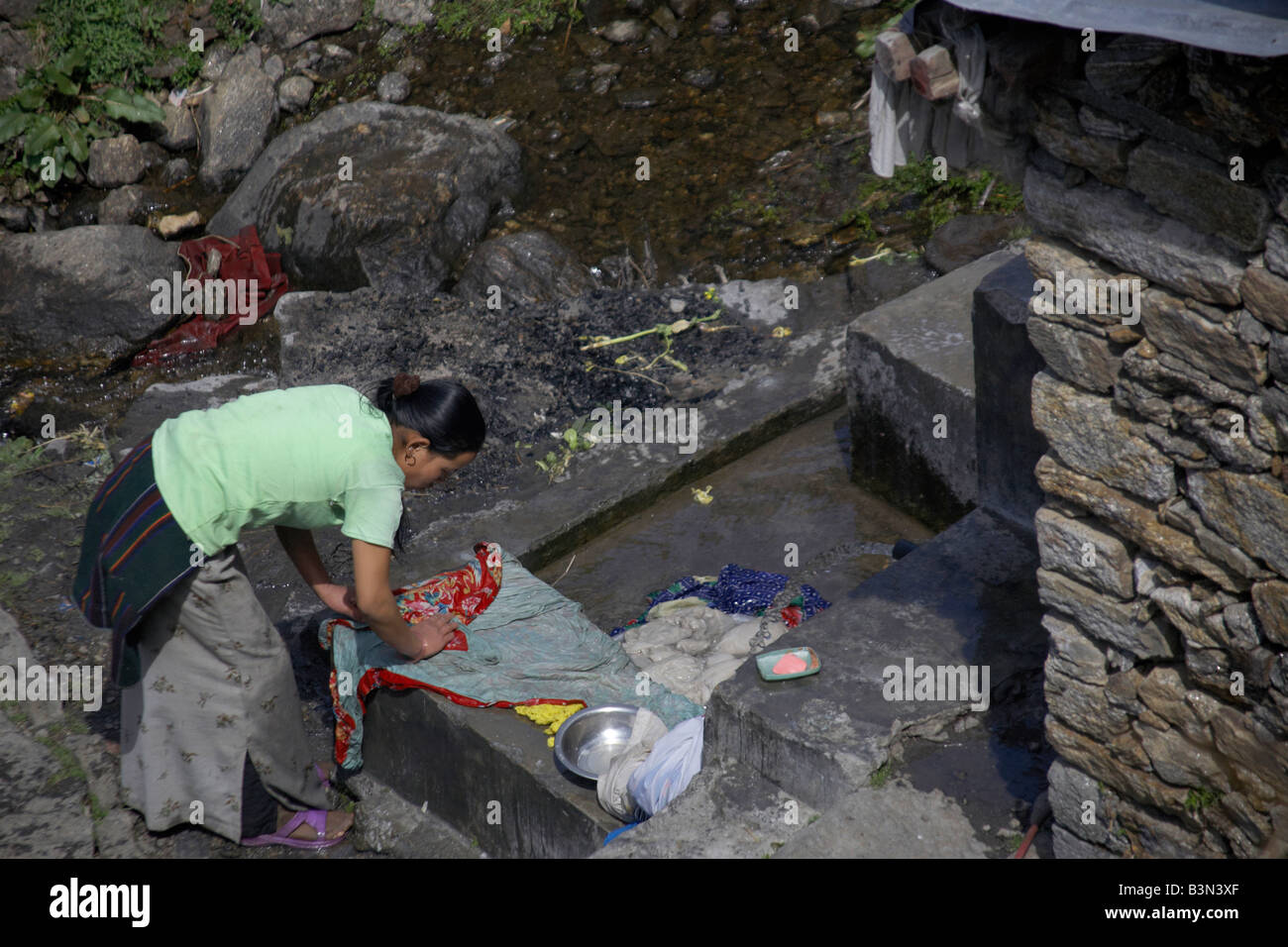 Nepalese woman washing clothes Stock Photo - Alamy