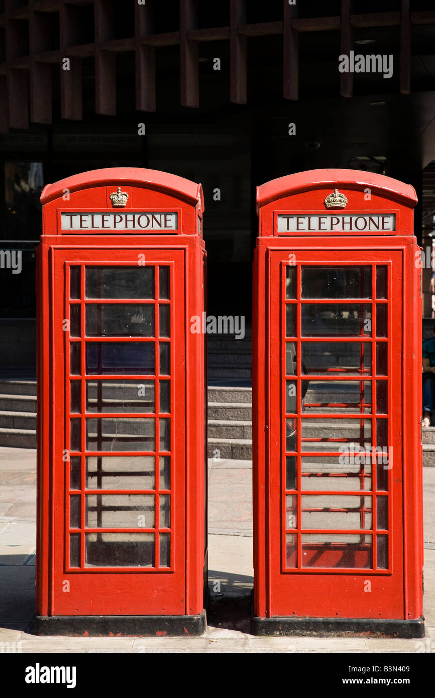 Two traditional red telephone boxes together on a London street ...