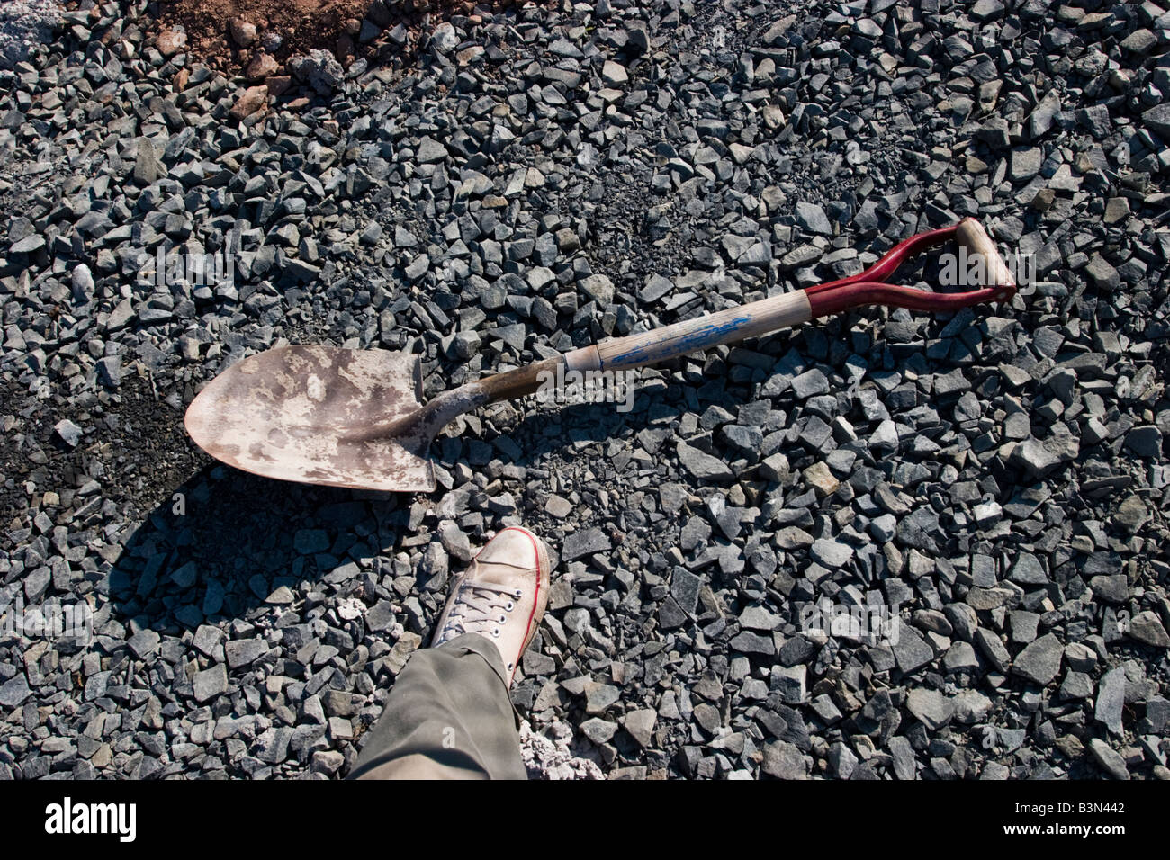Shovel next to a foot laying on the ground in a construction area in ...