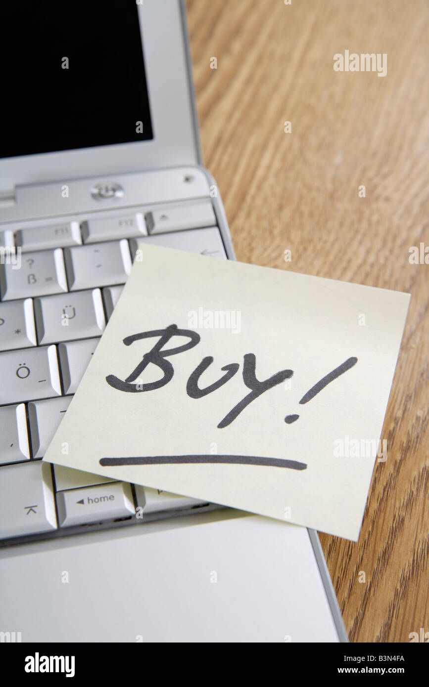 Adhesive note on laptop saying "Buy Stock Photo - Alamy